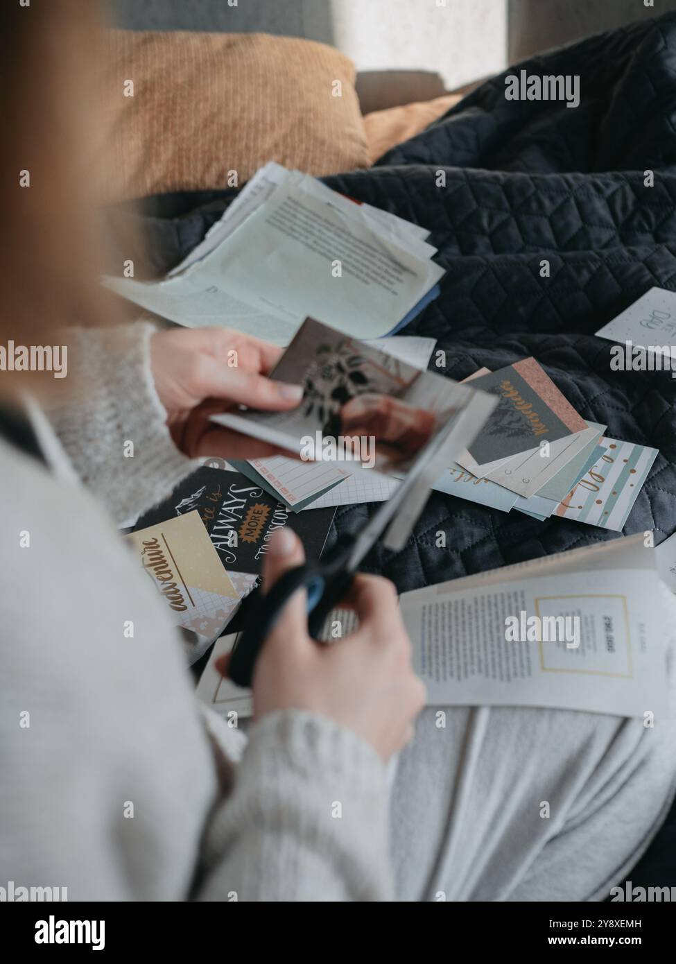 Woman scrapbooking cutting magazines for a vision board with scissors ...