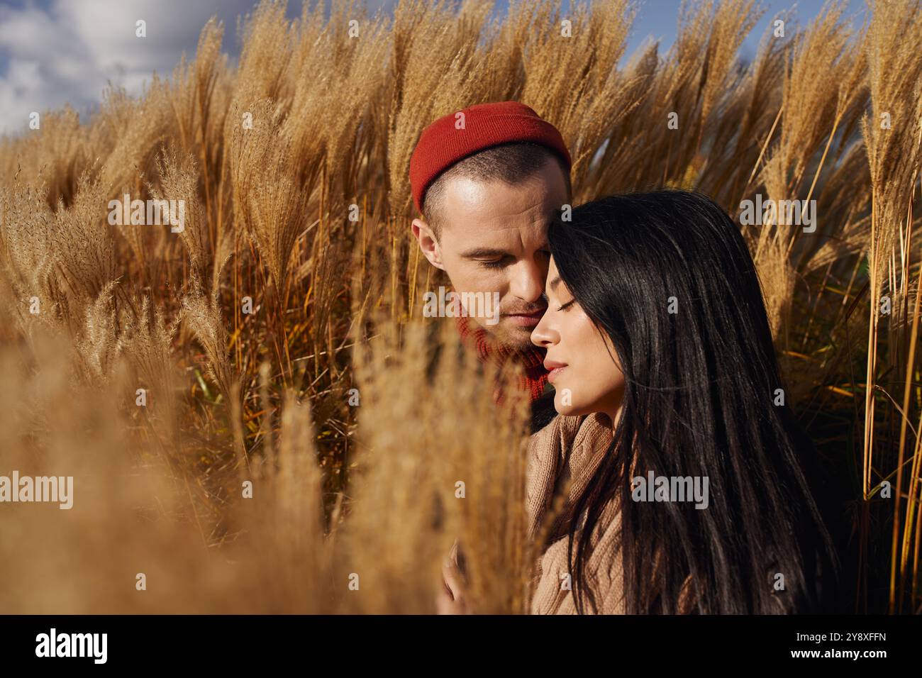 A cozy couple shares an intimate moment surrounded by autumns golden ...