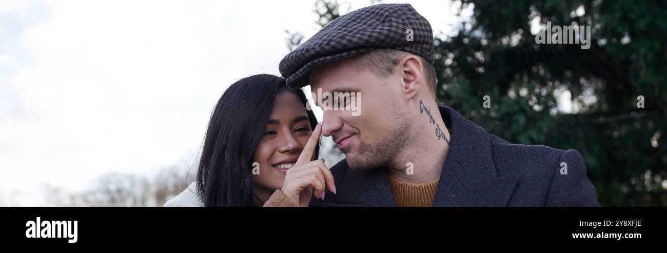 A cheerful couple shares an intimate moment, immersed in autumn cozy ...