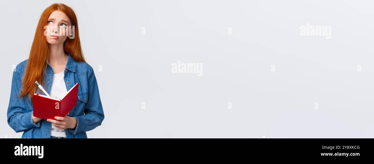 Uneasy and gloomy, indecisive cute redhead girl writing down her ...