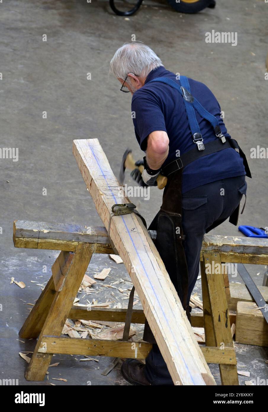 skilled shipright working with axe on traditional boatbuilding project ...
