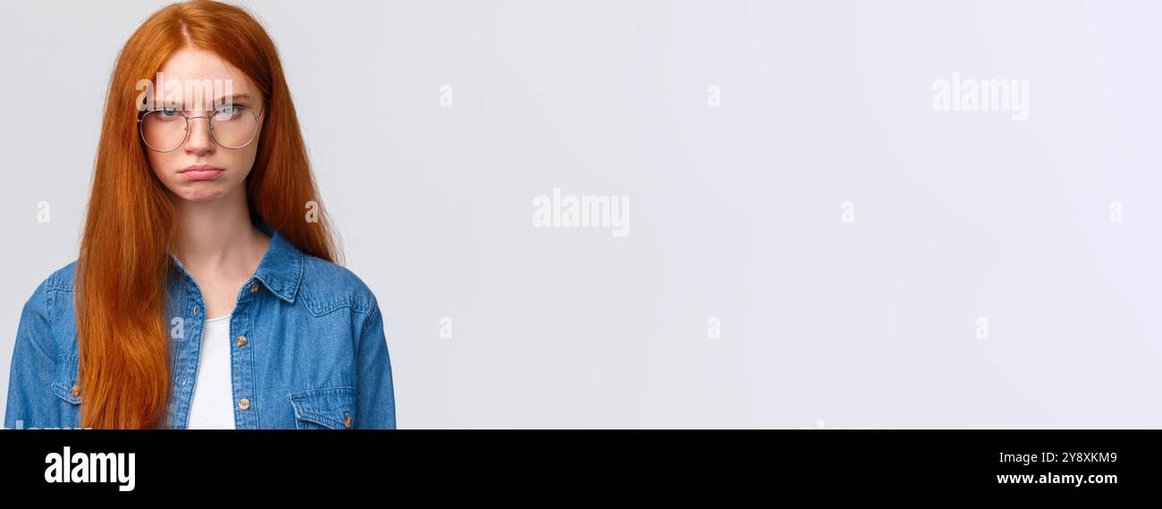 Close-up portrait strict and angry, mad gloomy redhead girl staring ...