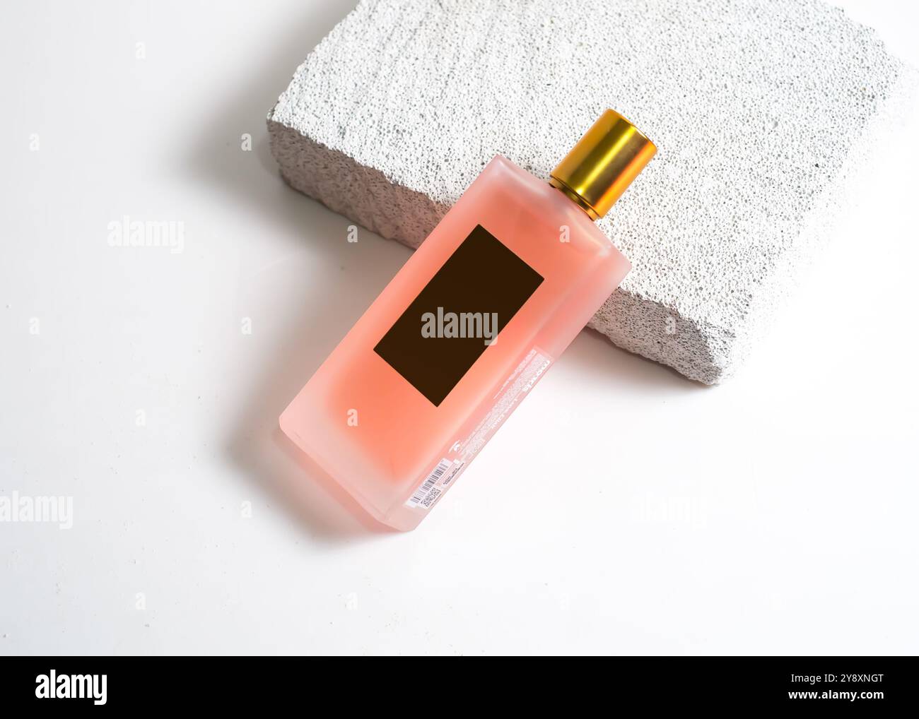 An elegant peach color spray perfume bottle showcased against a clean ...