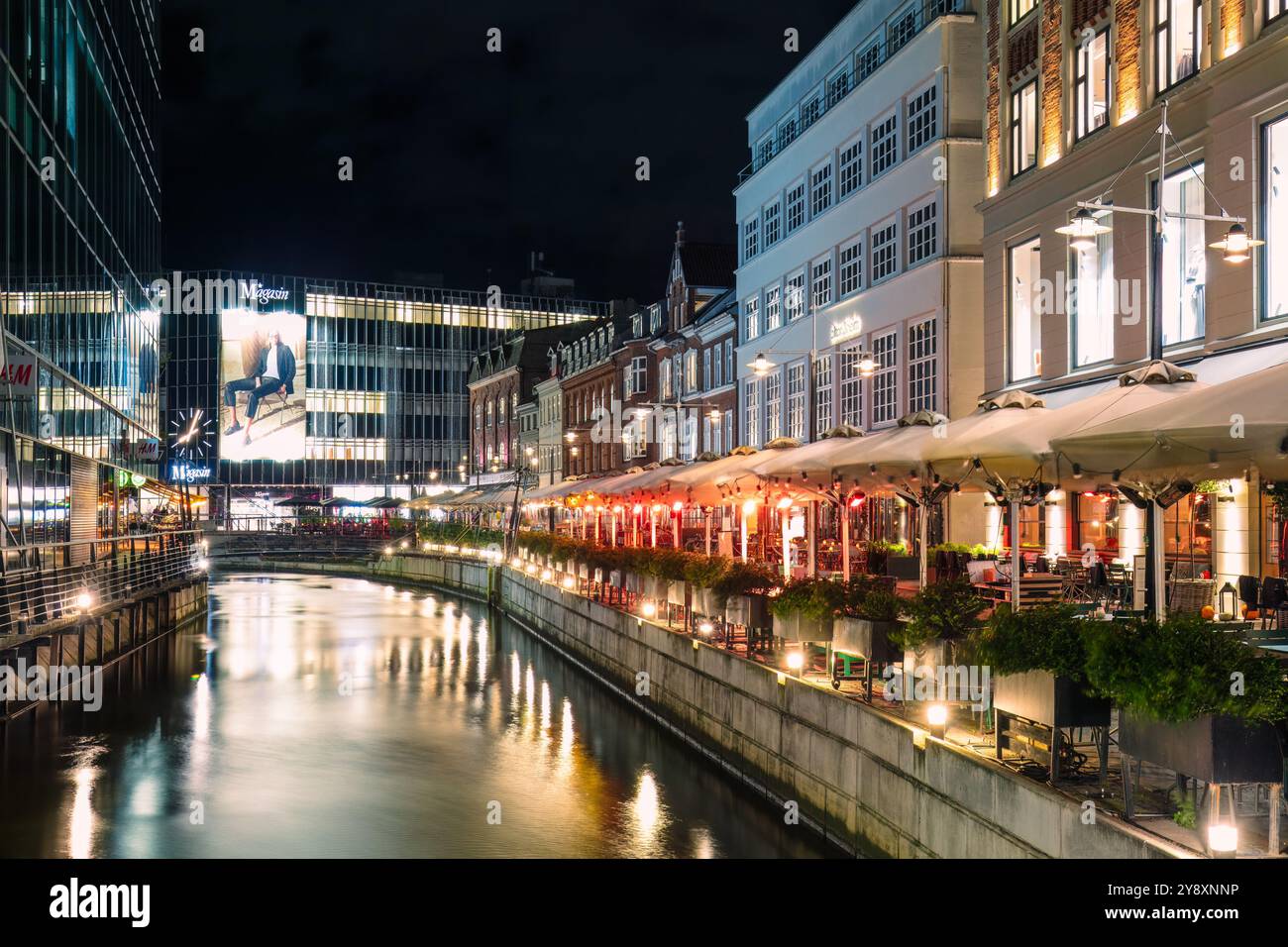 Night view of the Aarhus river canal lined with restaurants, cafes, and ...