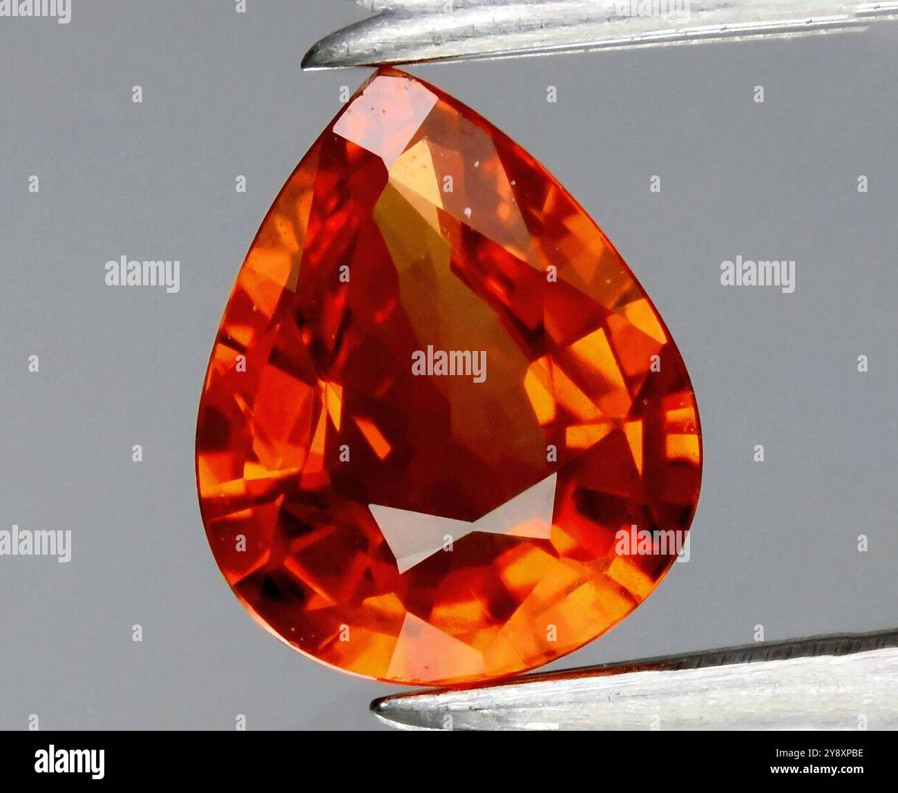 Radiant Orange Gemstone Captured in a Holding Tool Stock Photo - Alamy
