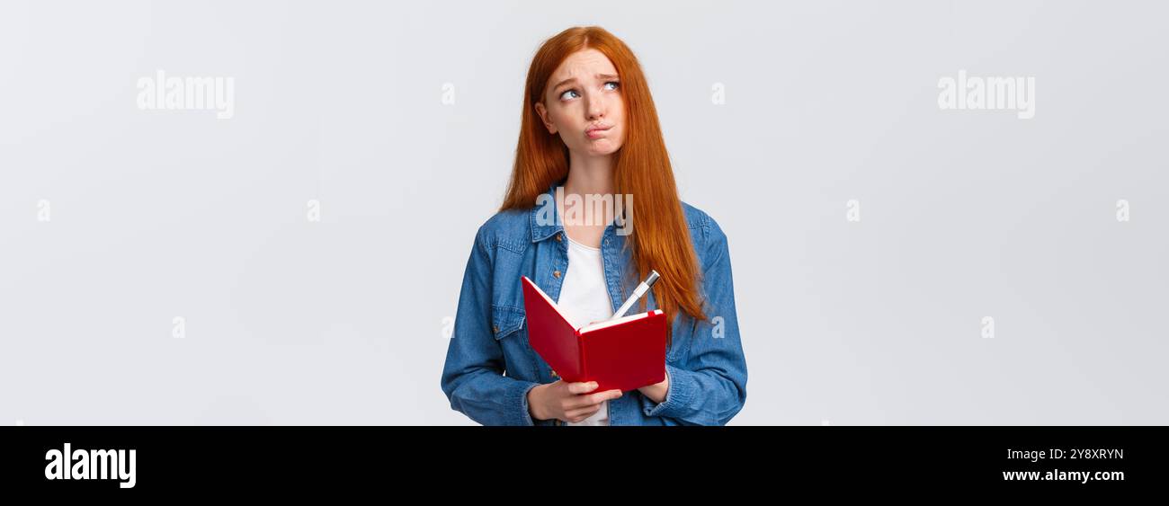 Uneasy and gloomy, indecisive cute redhead girl writing down her ...