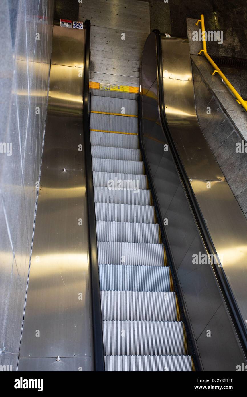 Overhead view of a gray escalator and bright yellow railing Stock Photo ...