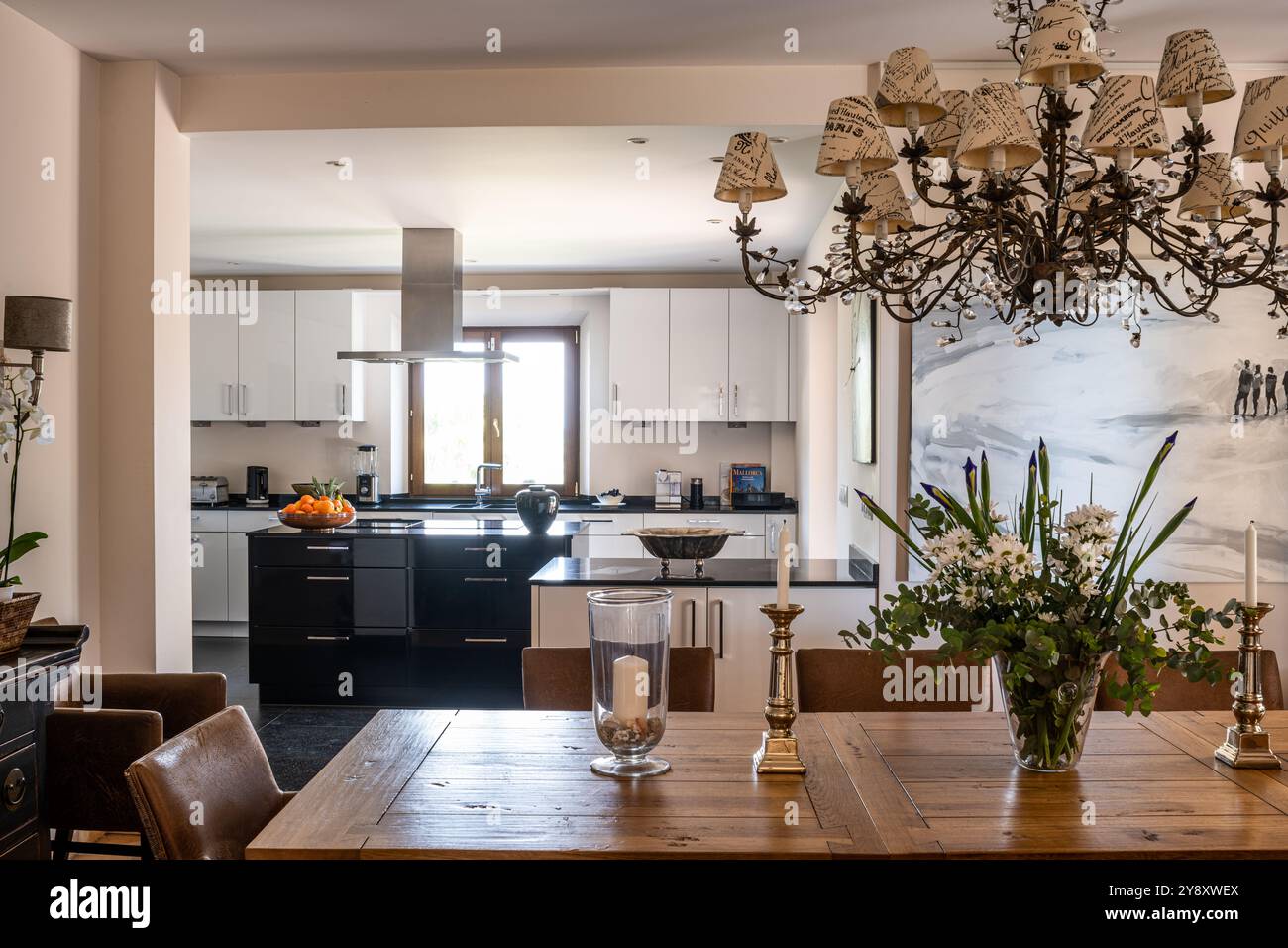 Chandelier above dining table with view to modern kitchen in Spanish ...