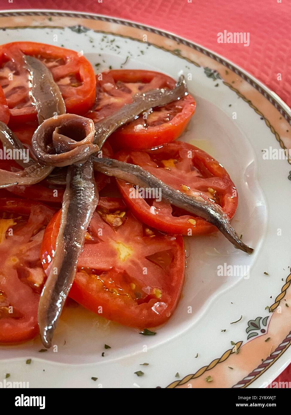 Salad made of sliced tomato, anchovy fillets and olive oil Stock Photo ...