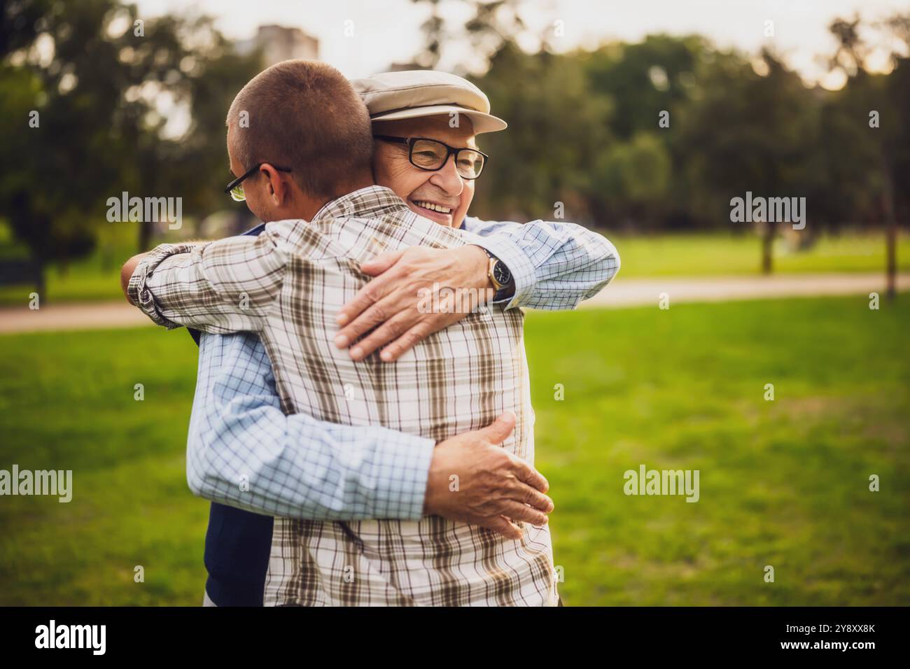 Happy grandfather and grandson are hugging and embracing in park Stock ...
