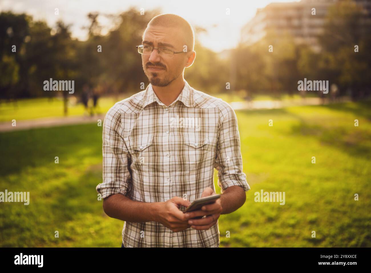 Portrait of worried adult man in park who is using smartphone Stock ...