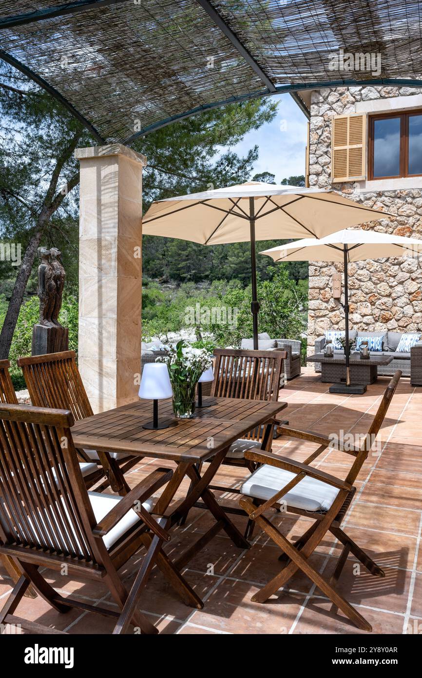 Wooden table and chairs on shaded terrace of Spanish villa, Mallorca ...