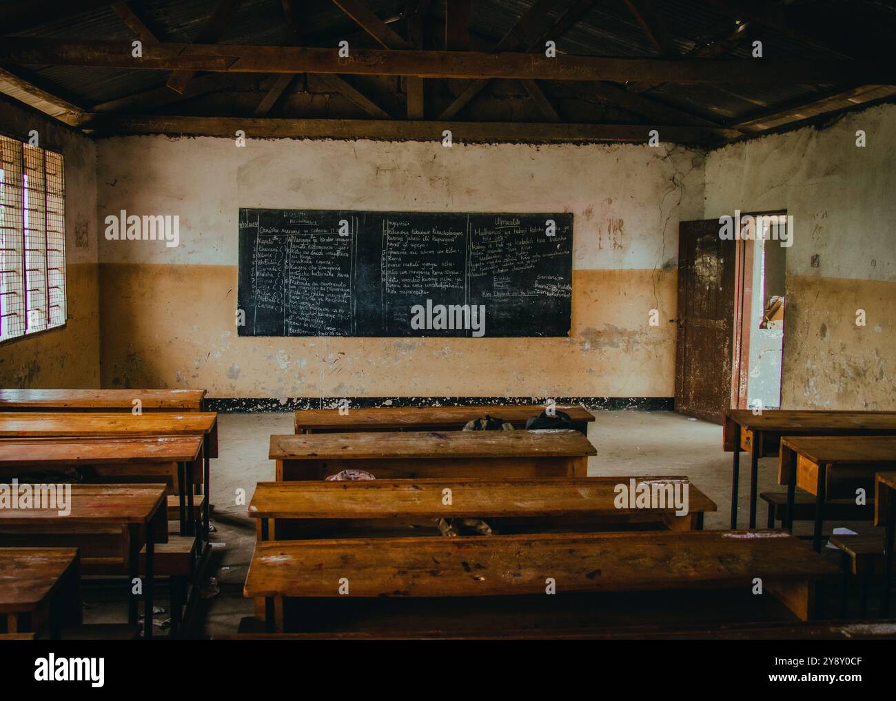a classroom with a wooden ceiling, a blackboard, a window and a wooden ...