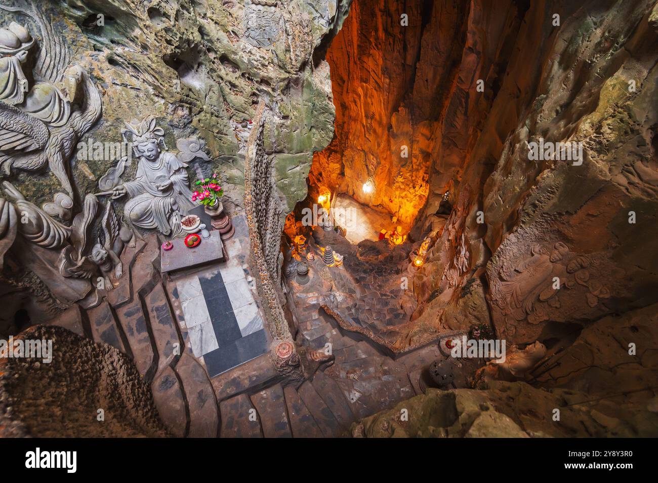 interior of deep large Am Phu cave with a Buddhist temple and sacred ...