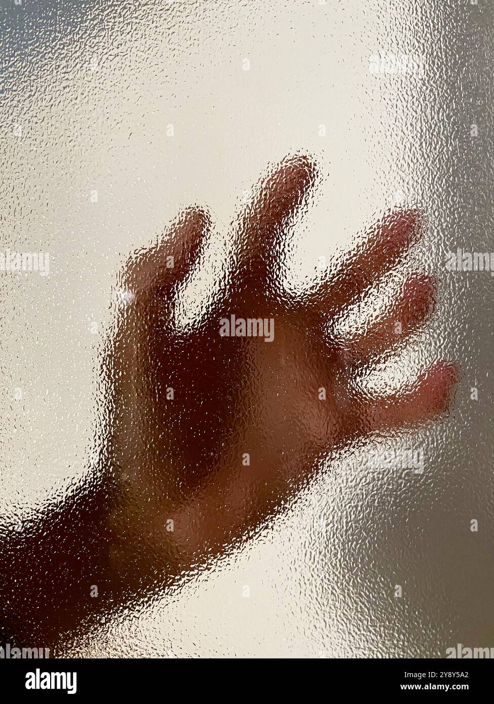 Tense hand behind ground glass Stock Photo - Alamy