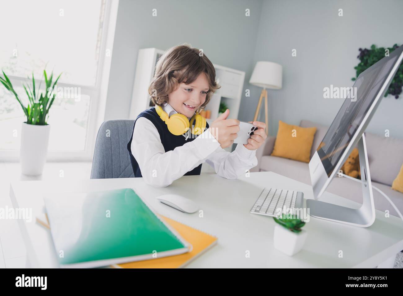 Portrait of positive charming smart clever learner boy sit chair table ...