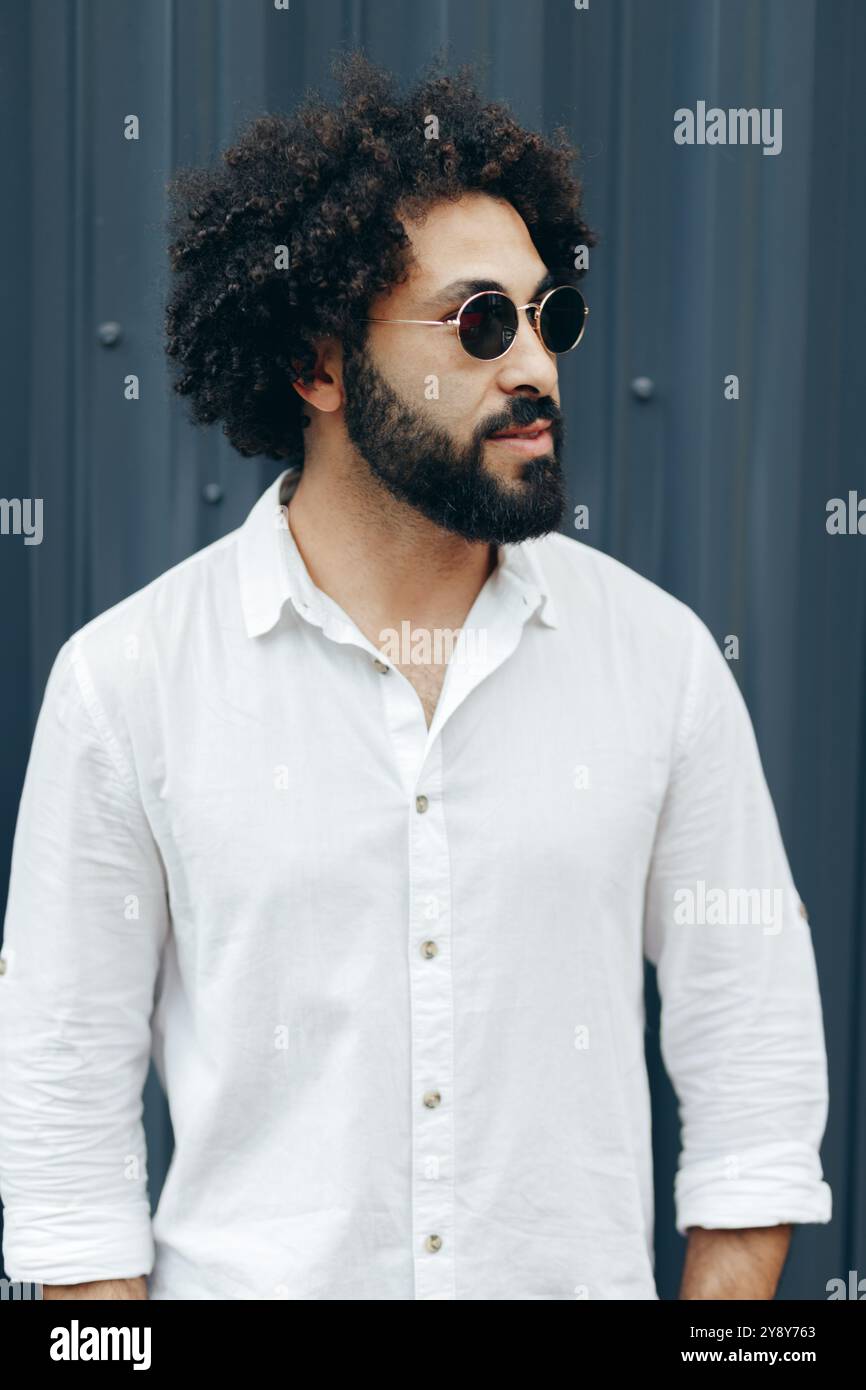 Arabian man with afro hairstyle and beard in white shirt standing at ...