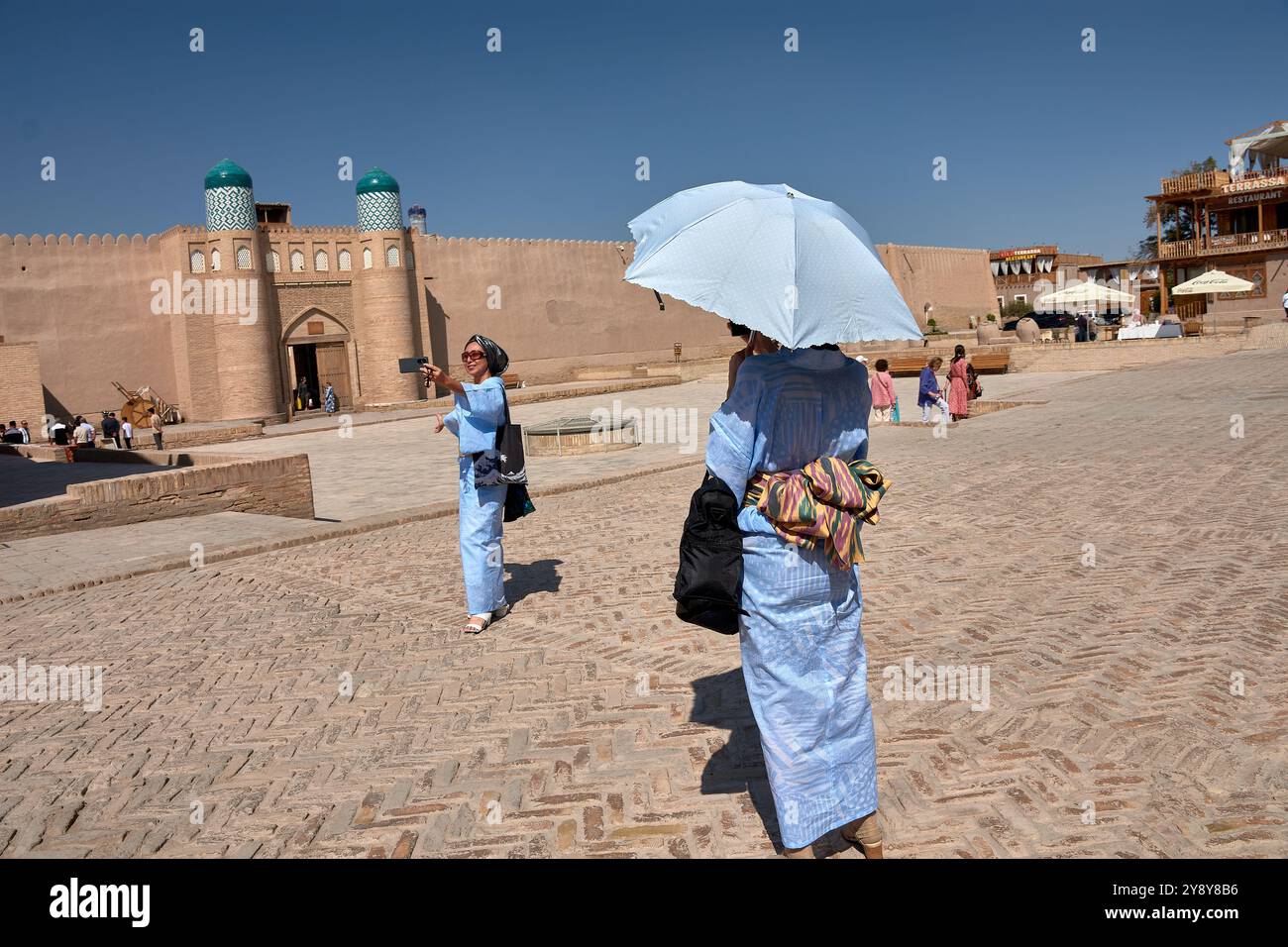 Khiva,Uzbekistan; September,21,2024:two women, both dressed in blue, as ...