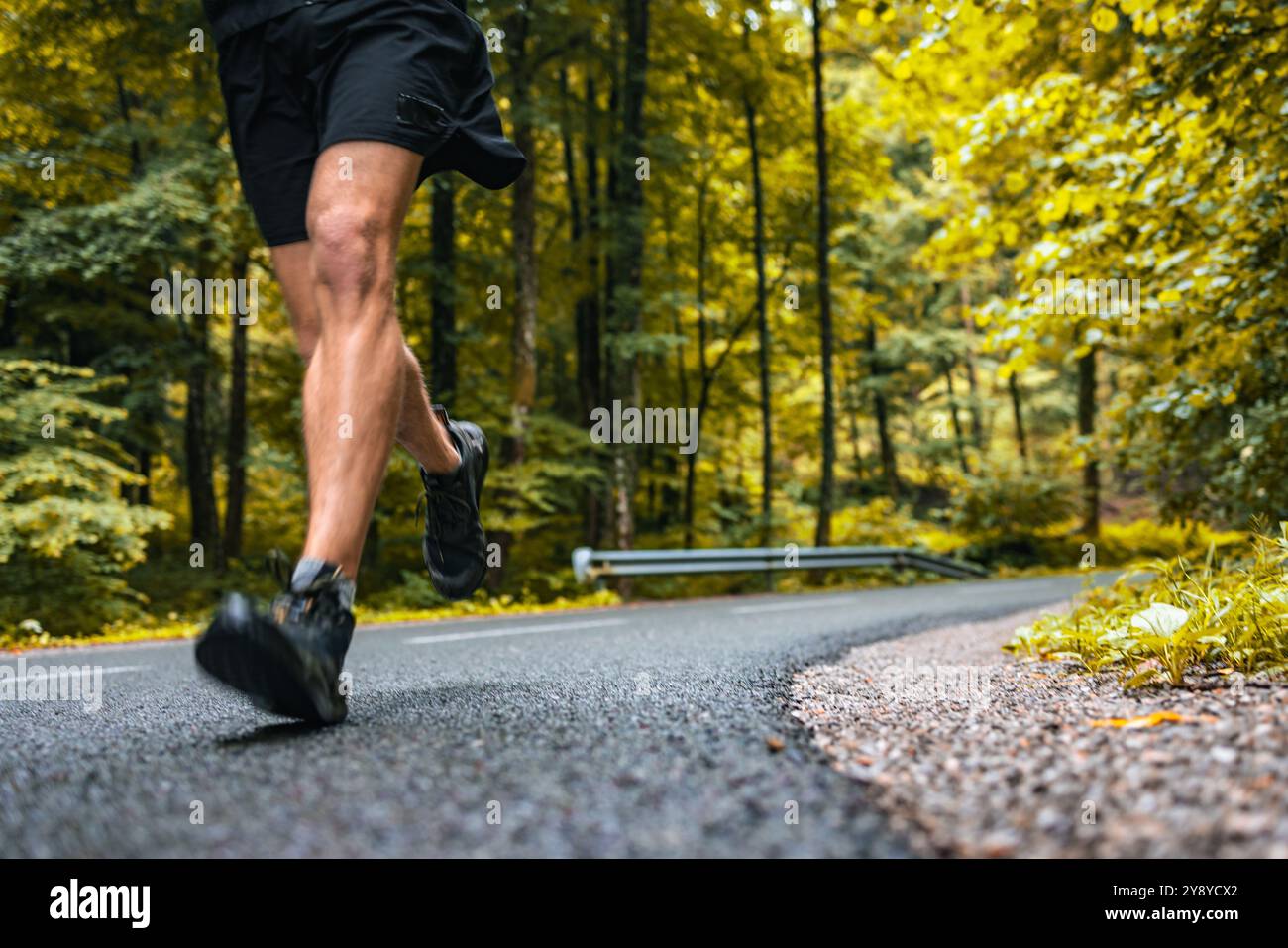 Unrecognized athletic build man running on an asphalt road Stock Photo ...