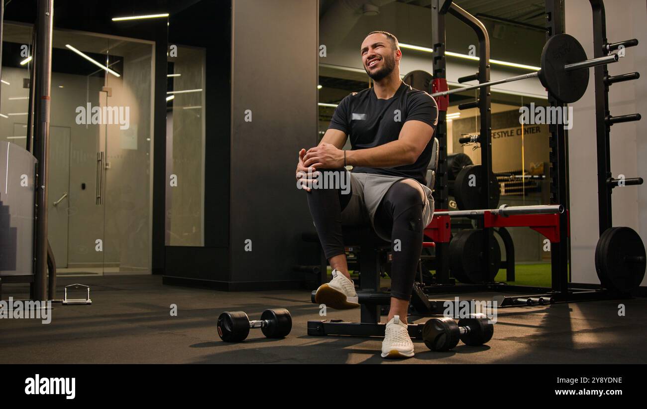 African American unwell man sad suffering with knee pain in sport club ...