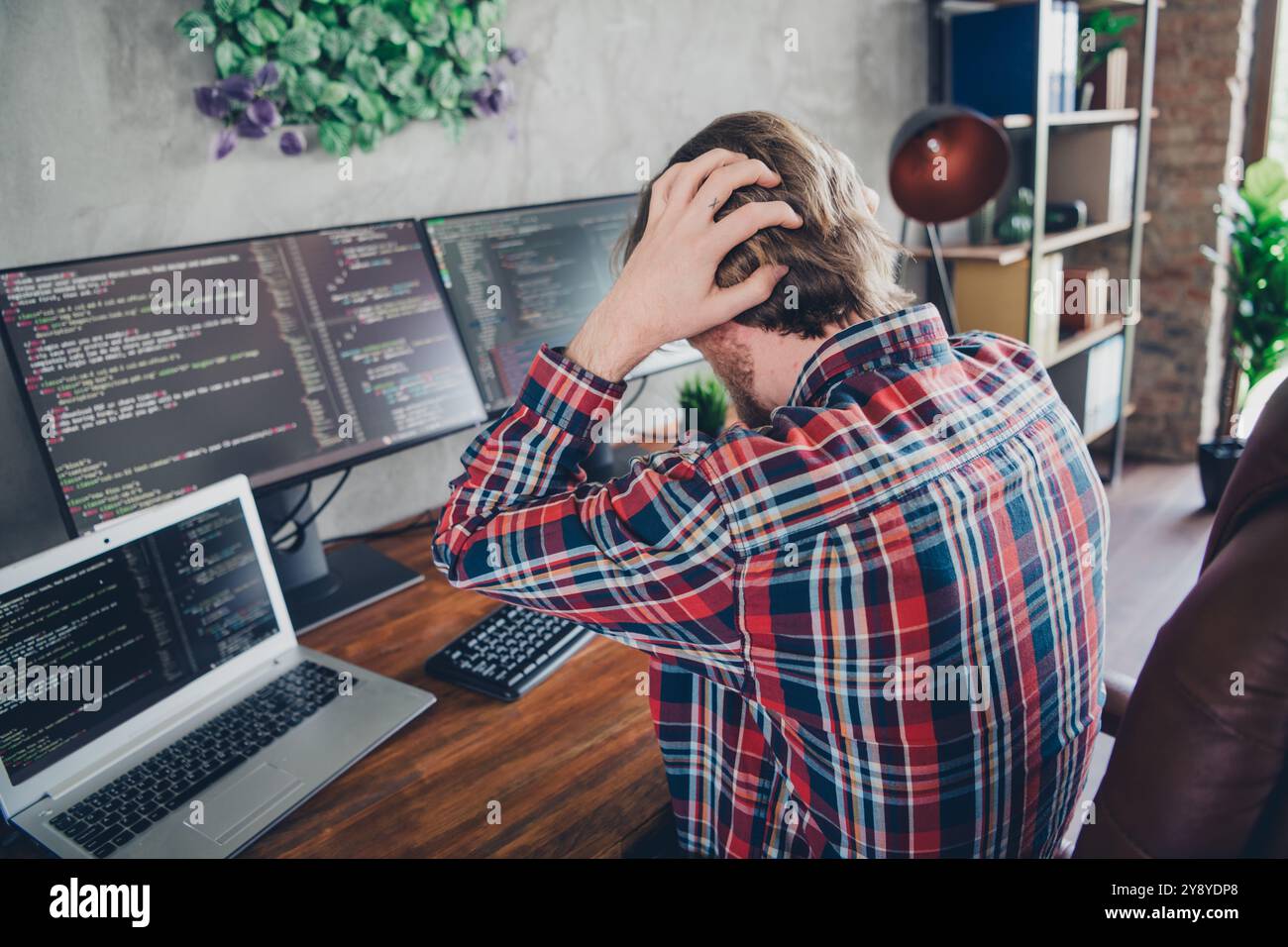 Photo of young stressed programmer man blond hair wearing eyeglasses and checkered shirt sitting ...