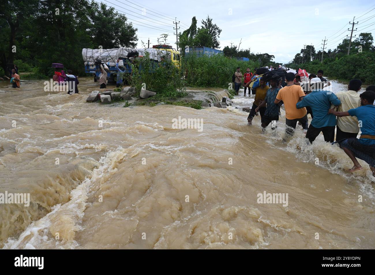 People wade through floodwaters in Feni District, Bangladesh, on August ...