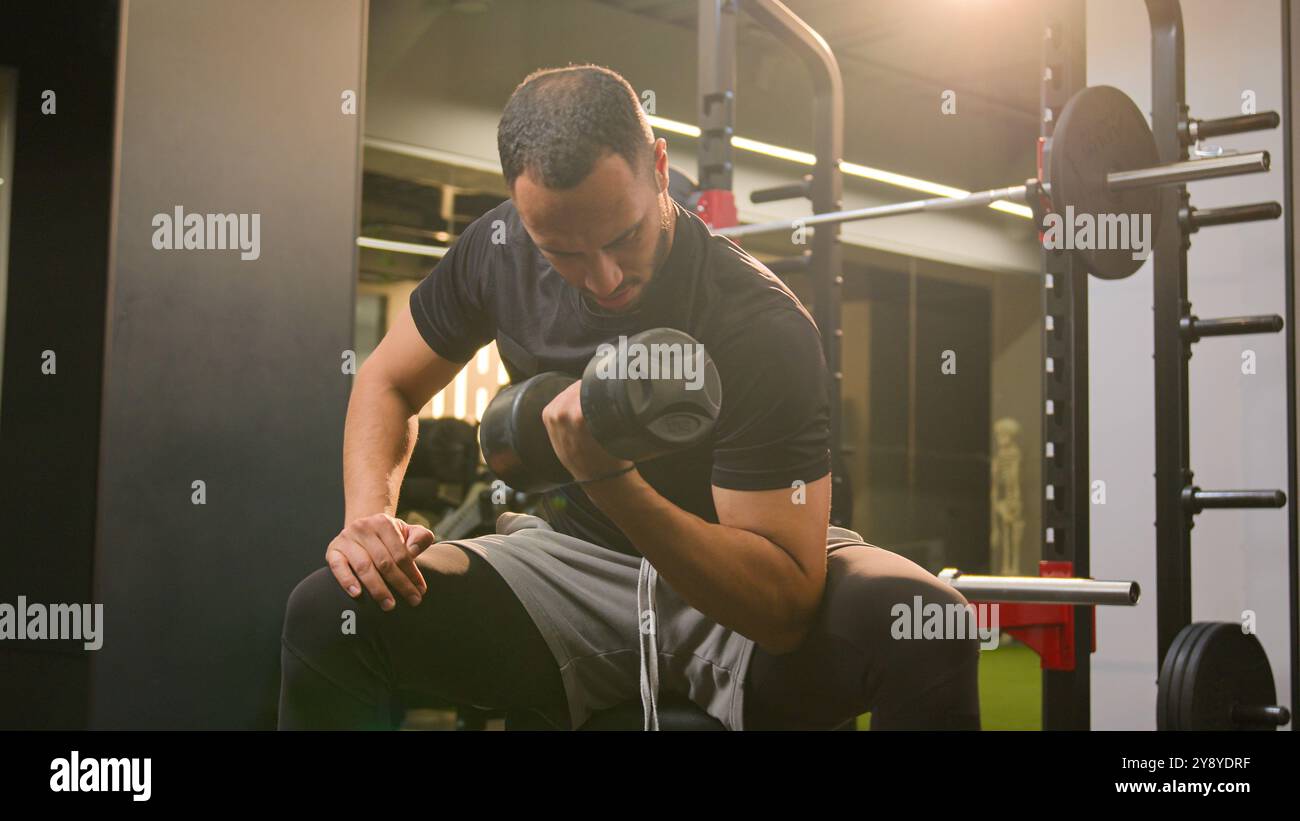 African American man in gym doing biceps workout exercise male ...