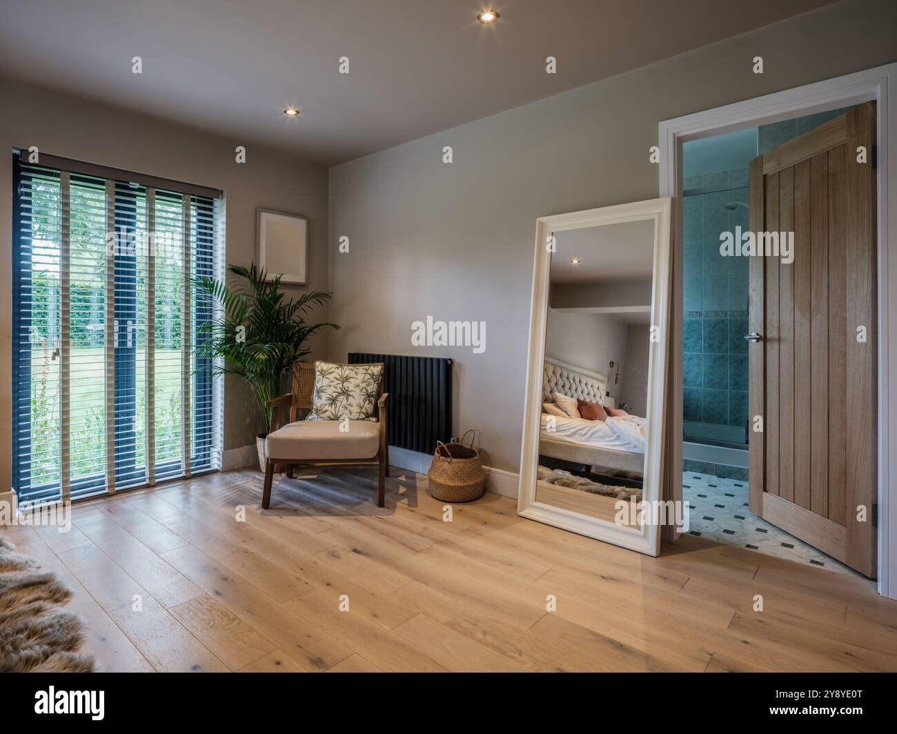 Luxury bedroom seating area with french doors and door open to en suite ...