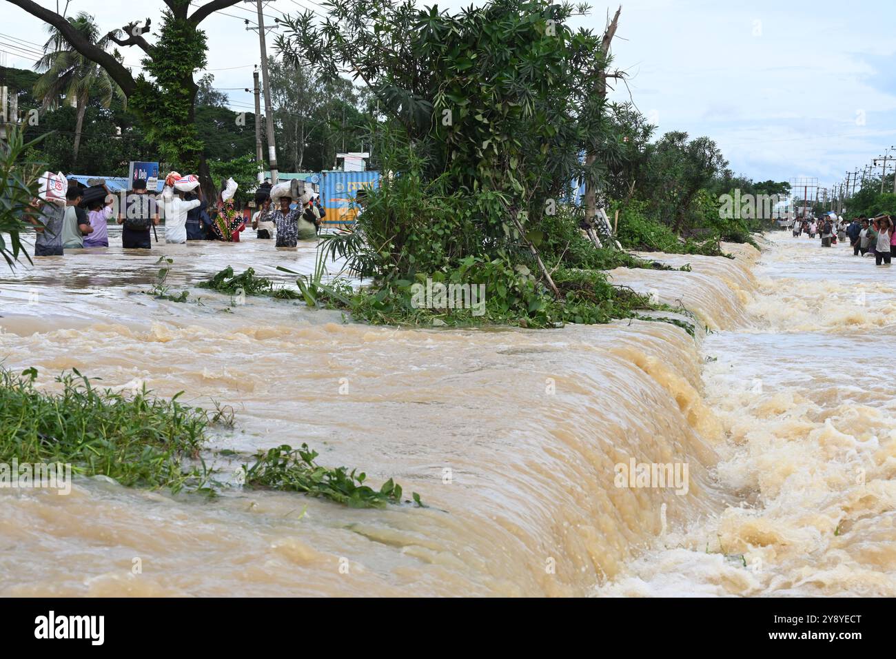 People wade through floodwaters in Feni District, Bangladesh, on August ...