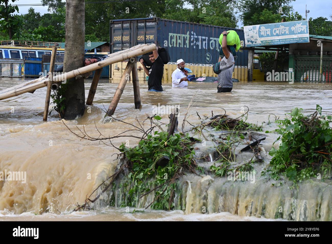 People wade through floodwaters in Feni District, Bangladesh, on August ...
