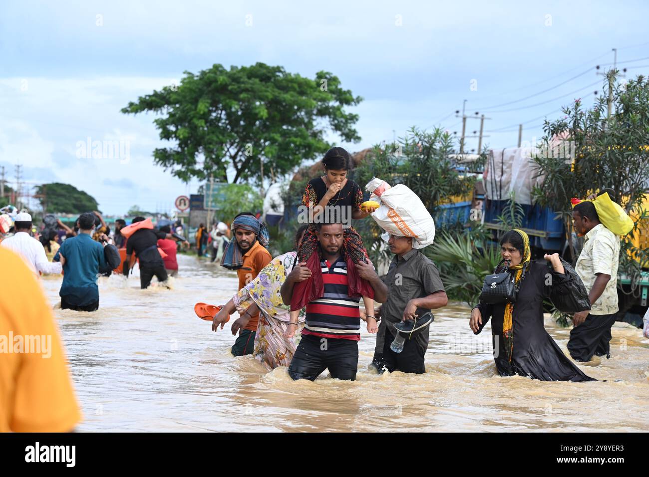 People wade through floodwaters in Feni District, Bangladesh, on August ...