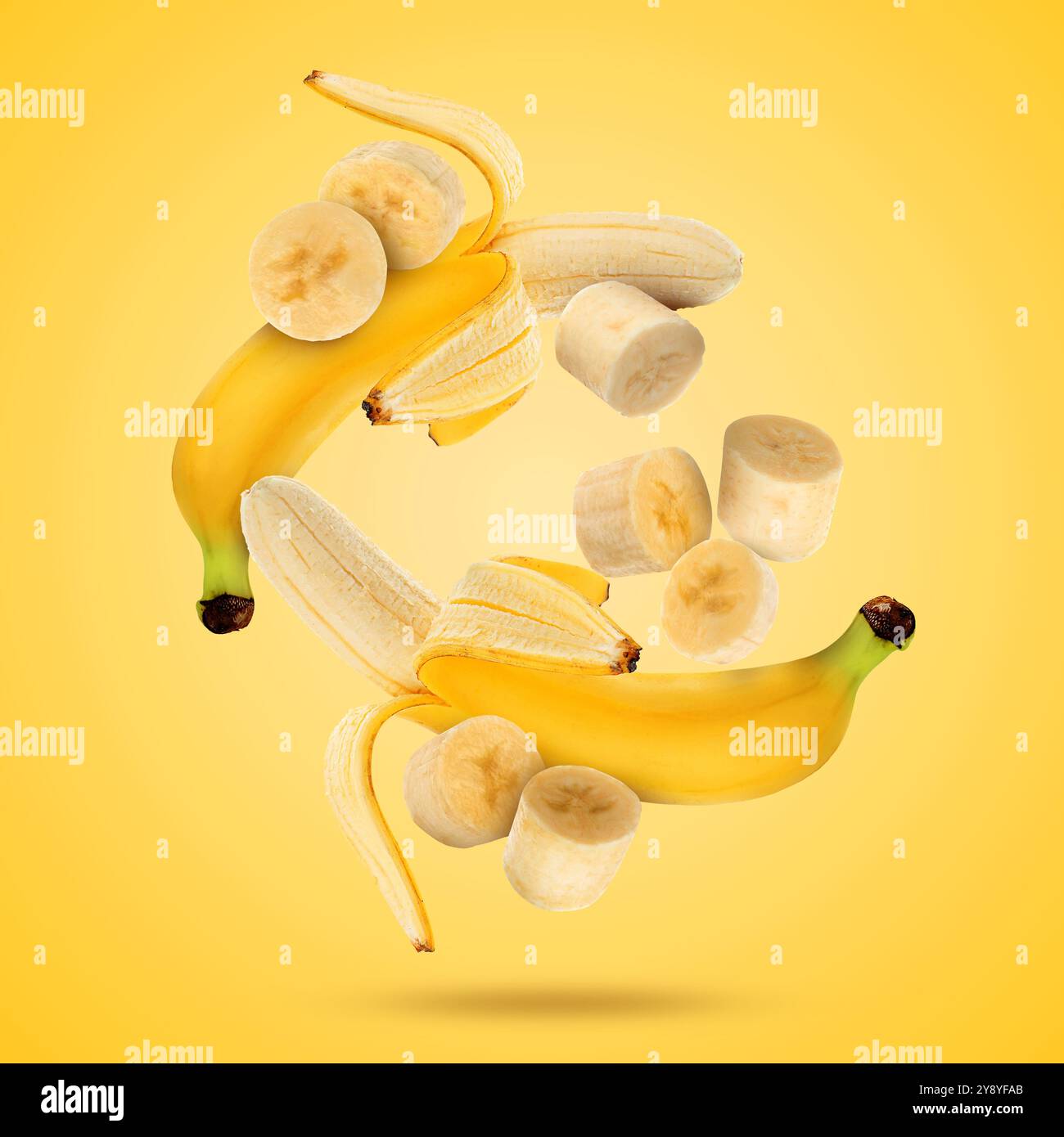 Fresh ripe bananas falling on golden background Stock Photo - Alamy