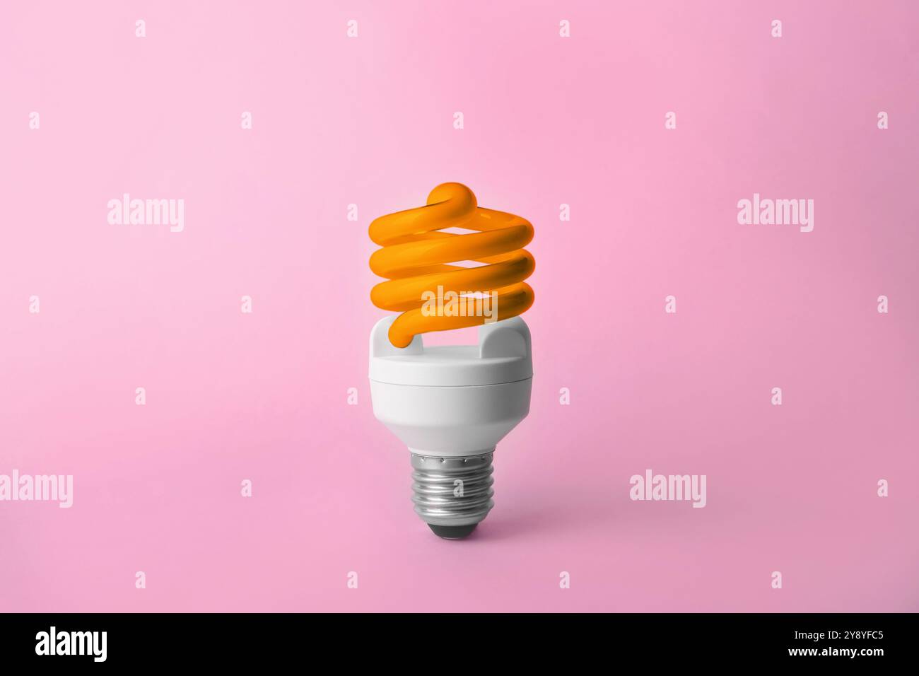 Orange fluorescent lamp bulb on pink background Stock Photo - Alamy