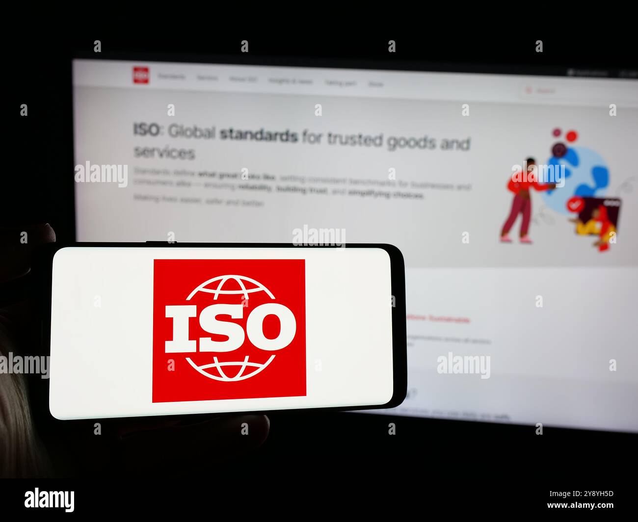 Person holding smartphone with logo of International Organization for ...