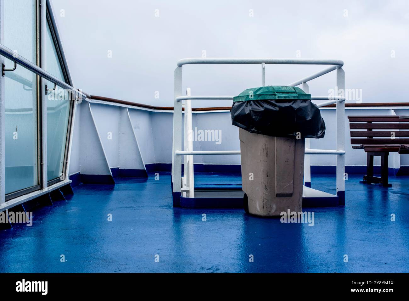 garbage bin on ship deck with blue floor and white railings Stock Photo ...
