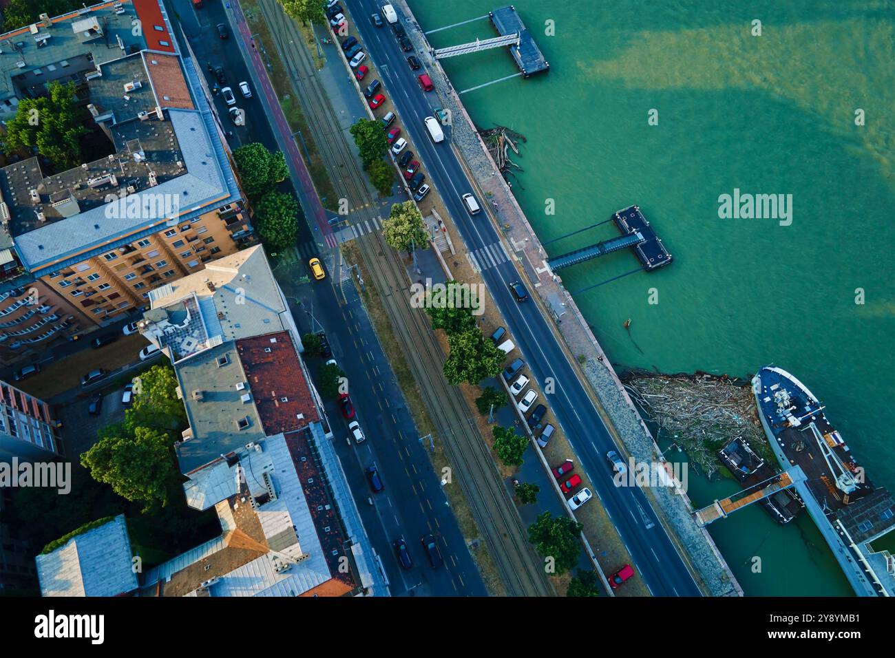 Aerial view of waterfront street in urban area with tram tracks, parked ...