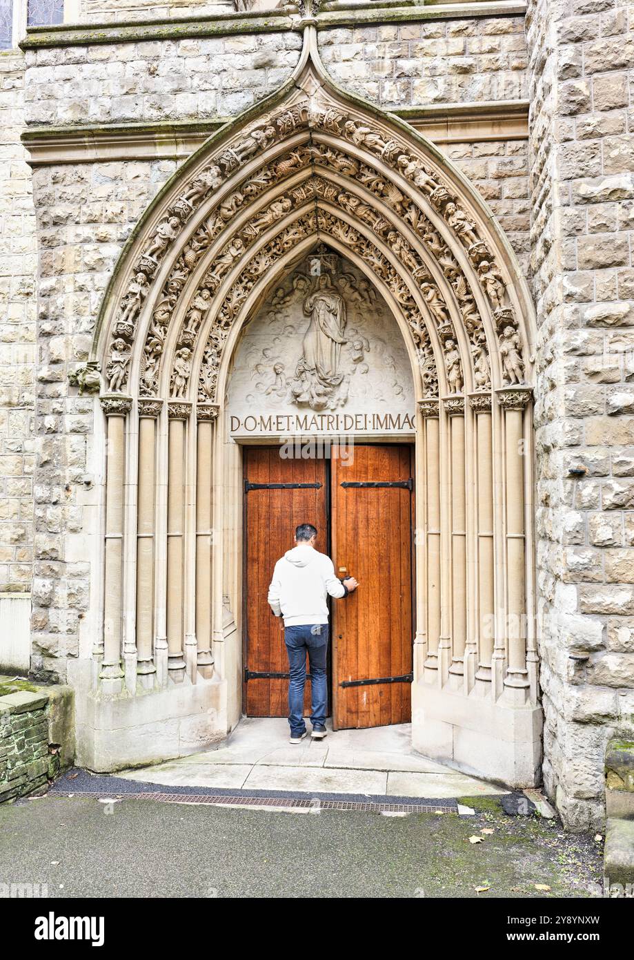 A man enters the Catholic christian church of the Immaculate Conception ...