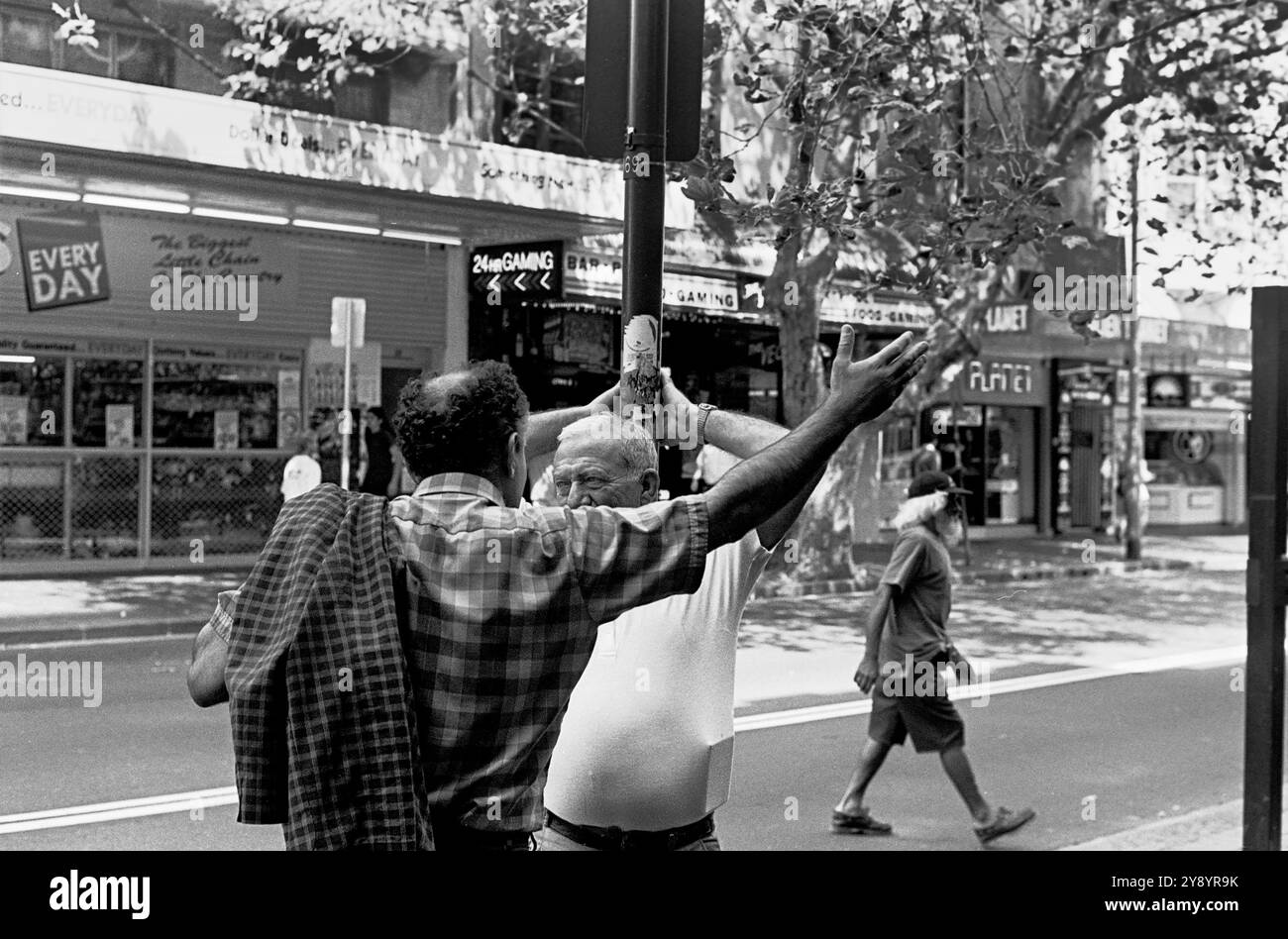 Street scene two men in conversation gesturing. Kings Cross area ...