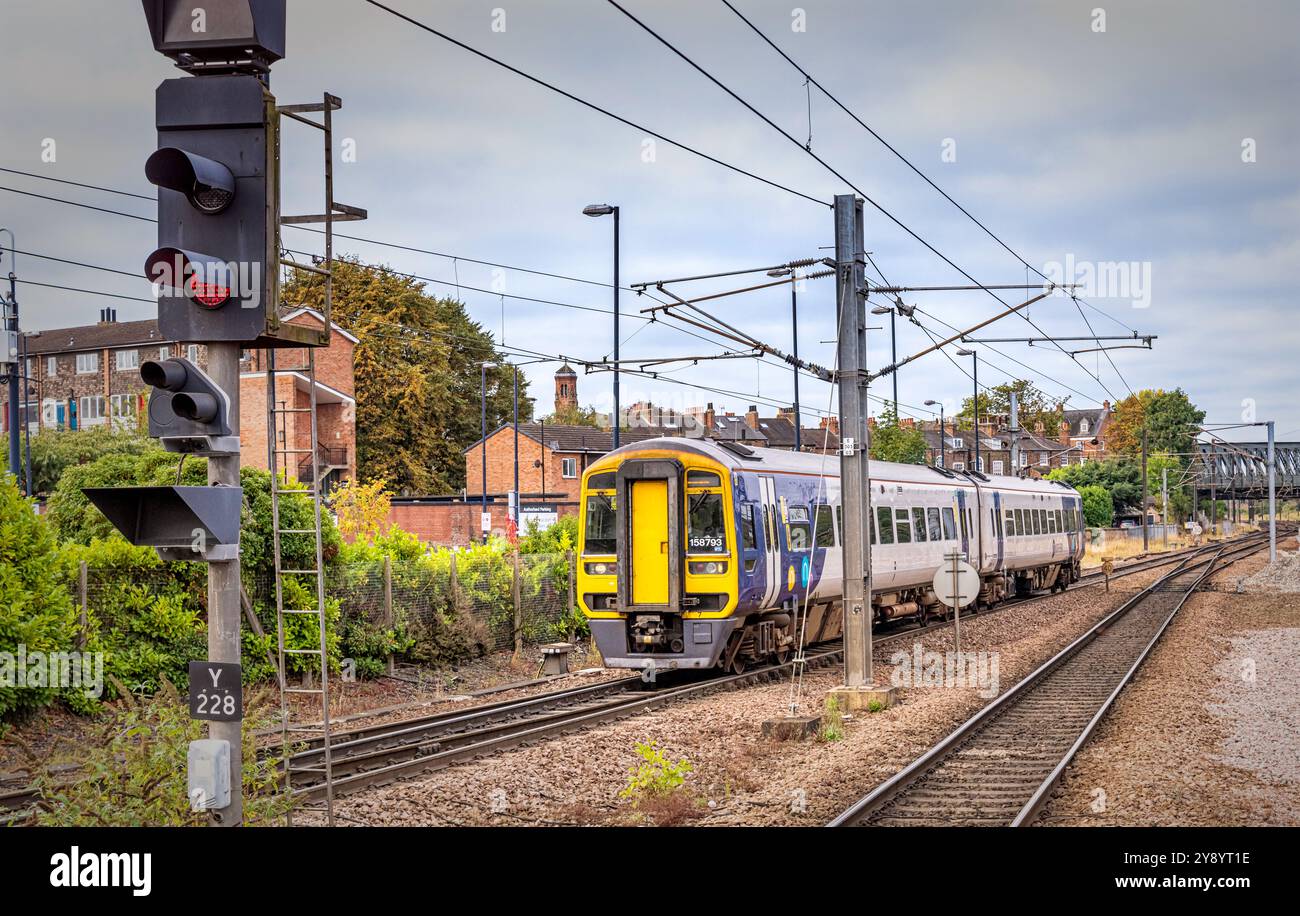 A locomotive pulling carriages approaches a railway station. A traffic ...