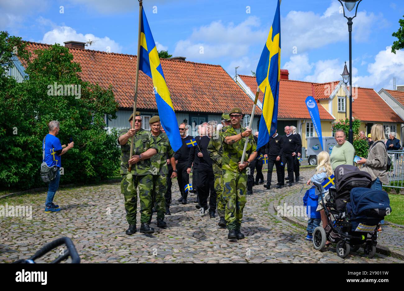 A military ceremony takes place outdoors under a clear blue sky, with ...