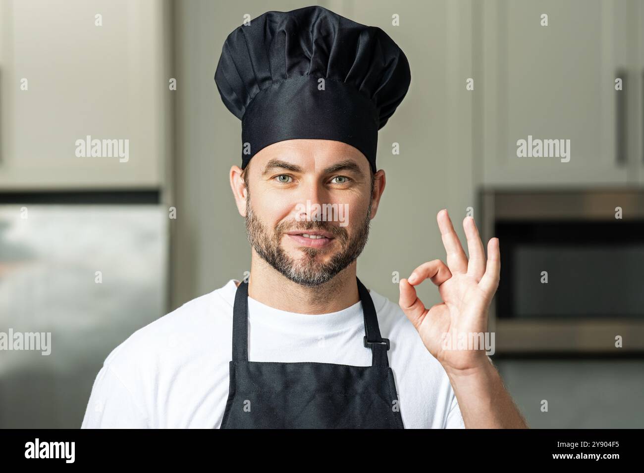 Handsome man chef in uniform cooking in the kitchen. Restaurant menu ...