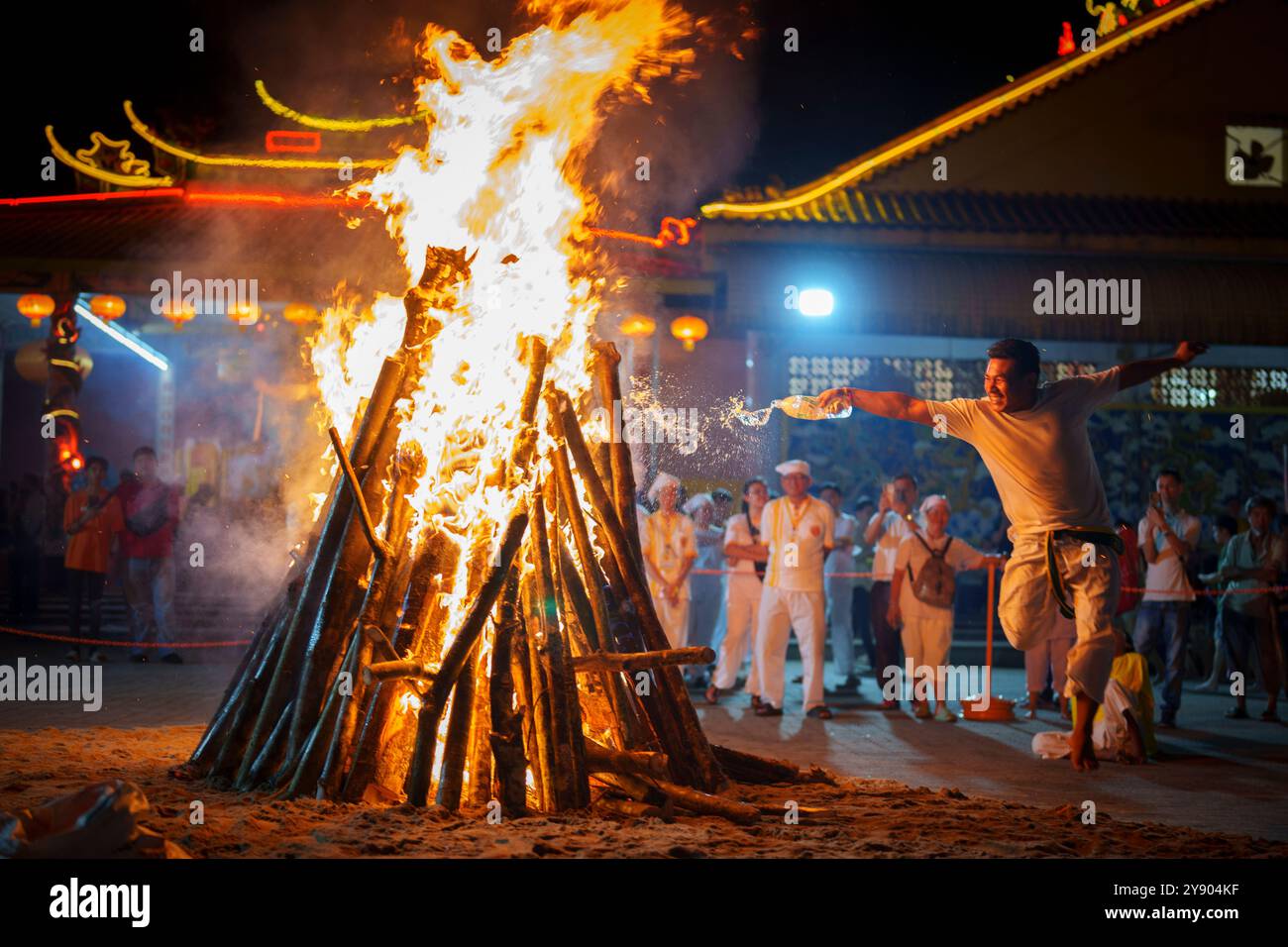 A man set wood on fire to prepare for worshippers to walk barefoot over ...