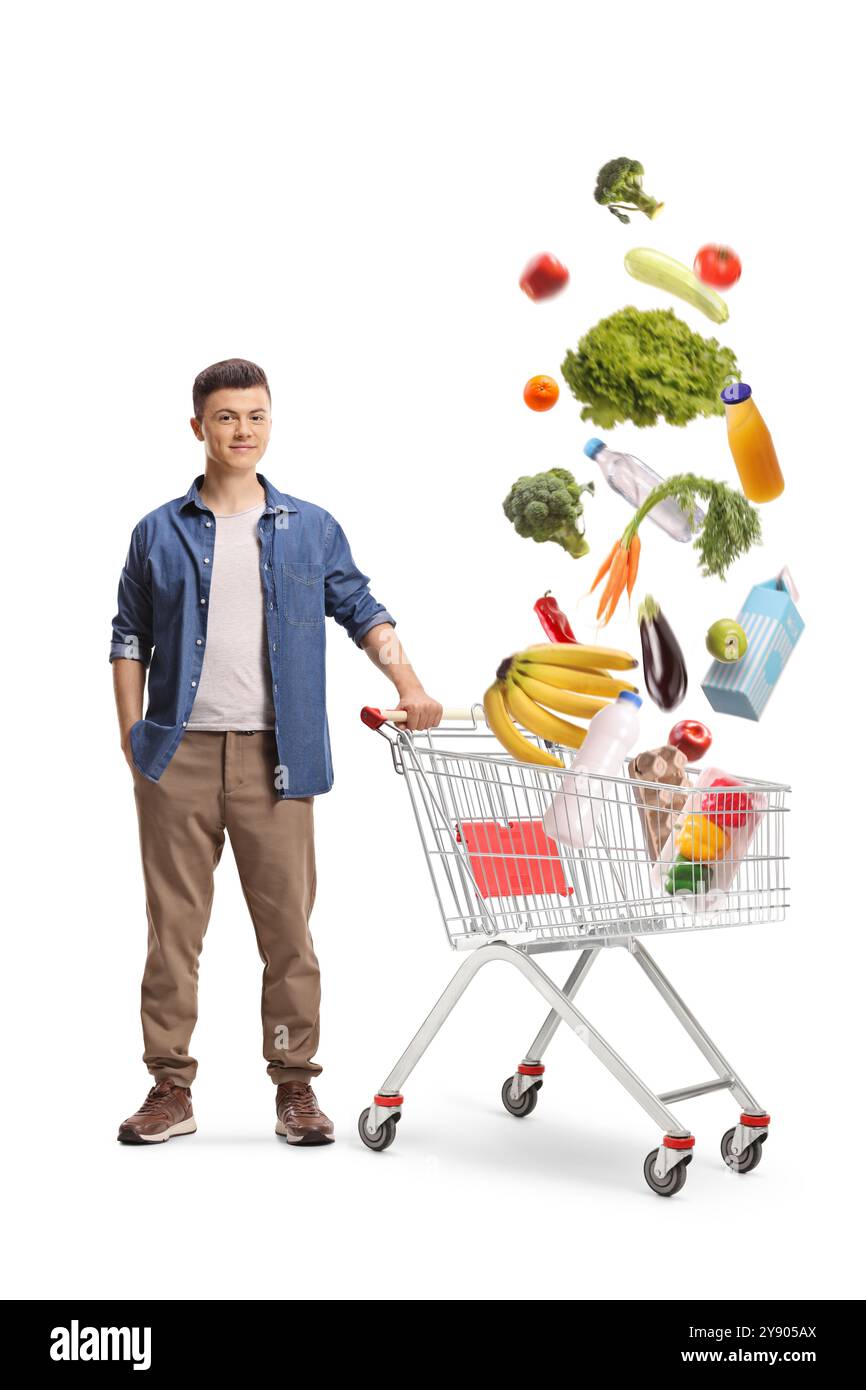 Young male customer with a shopping cart and food products falling ...