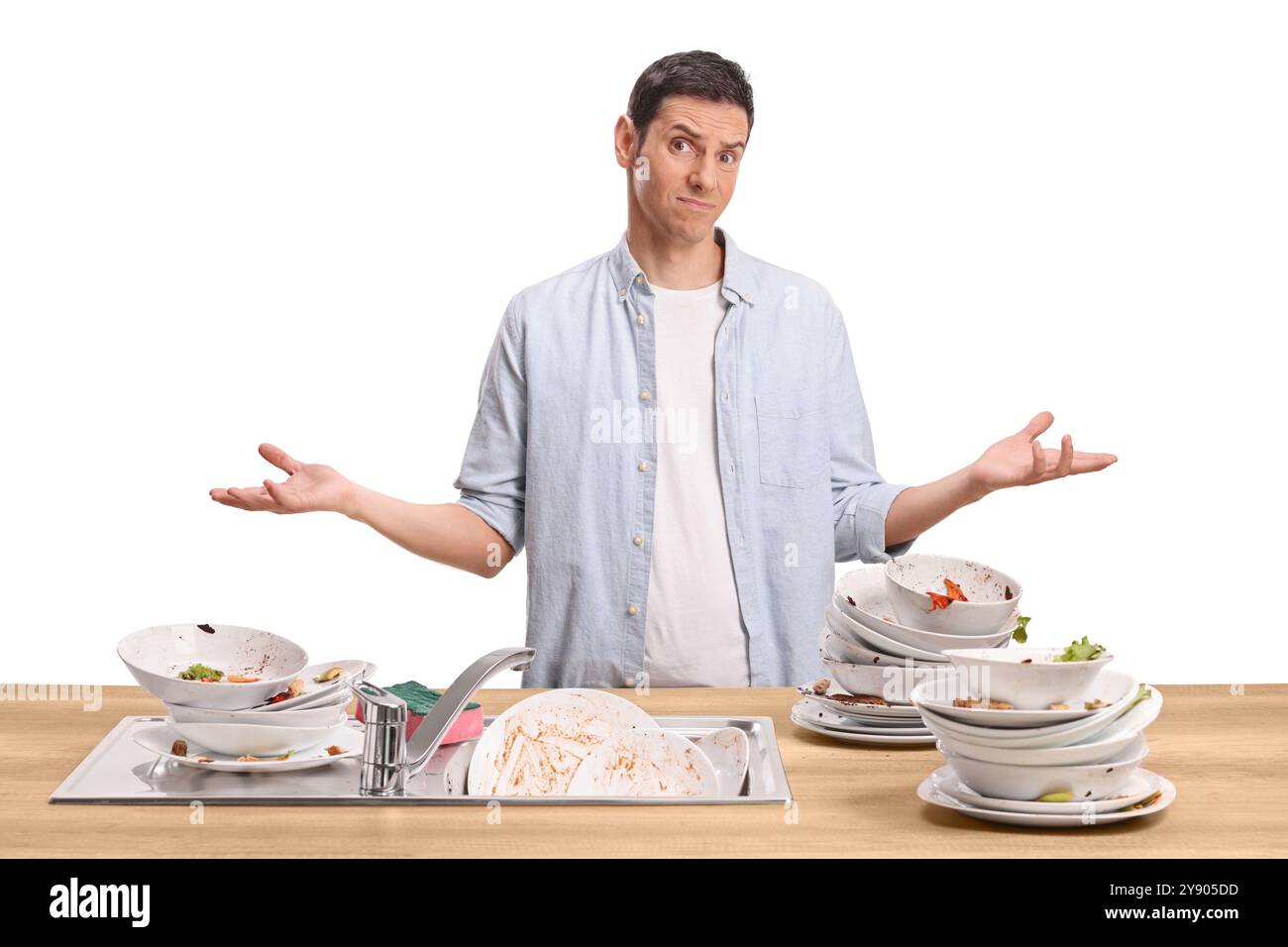 Confused young man with a pile of dirty dishes in a sink isolated on ...