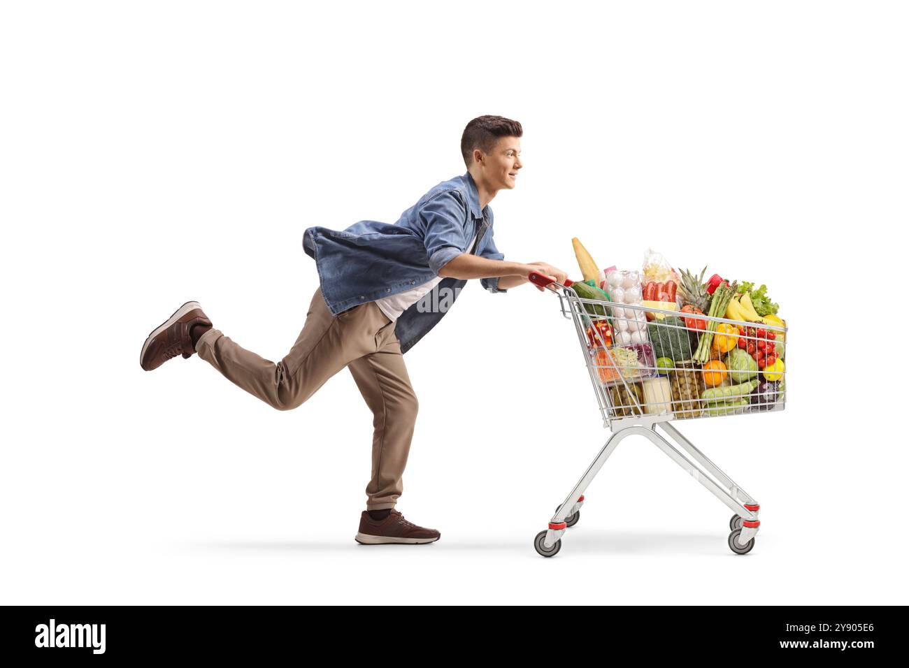 Teenager running with a shopping cart full of groceries isolated on ...
