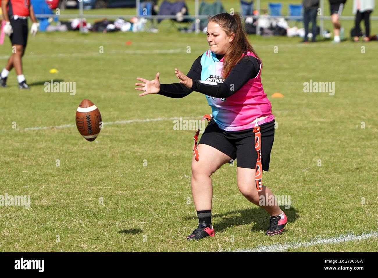 Female flag football quarterback receiving the ball to start the play ...