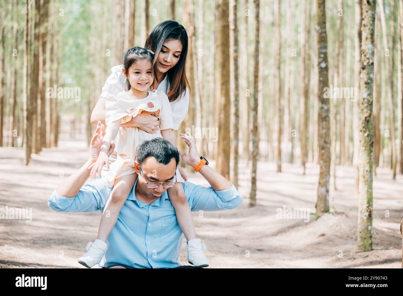 Family father carrying young girl shoulders while walking in forest with mother, Happy Asian ...