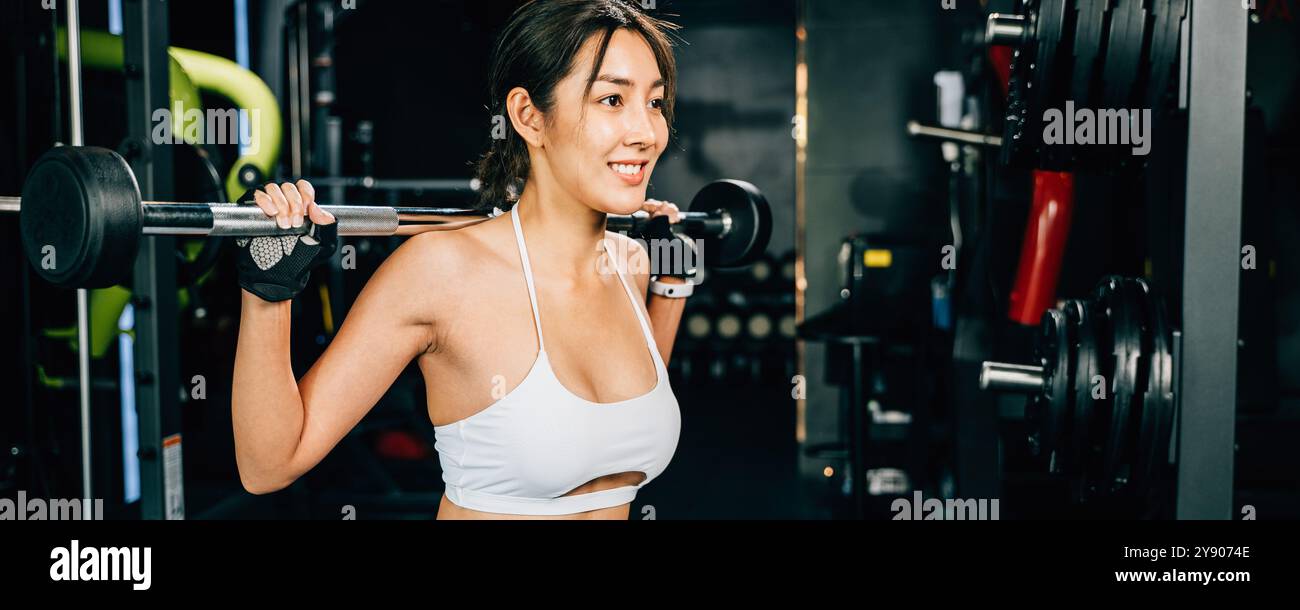 Asian woman muscular guy squat exercise with a lifting barbell in gym ...
