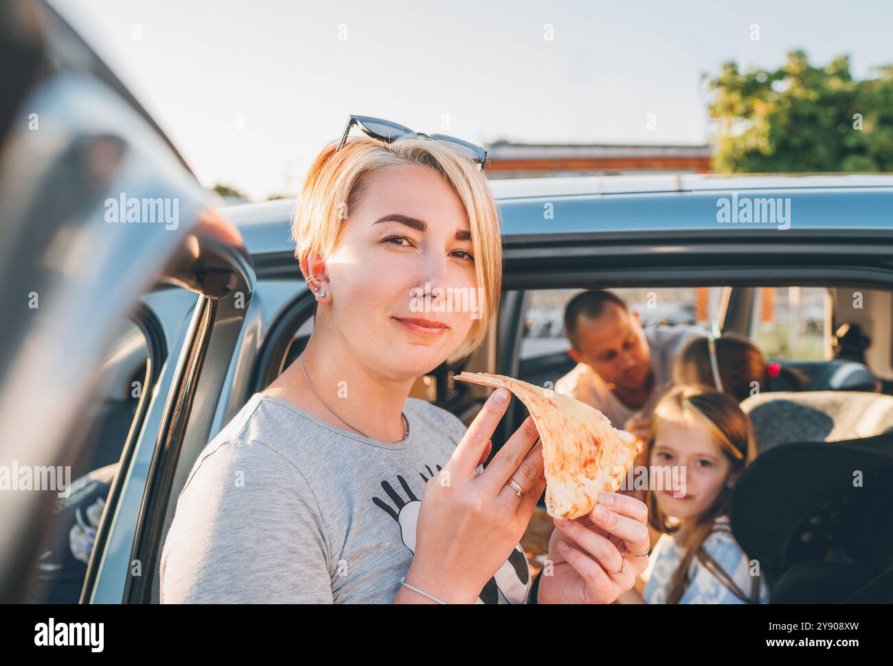 Positive smiling girl in child car seat while family car trip brake ...