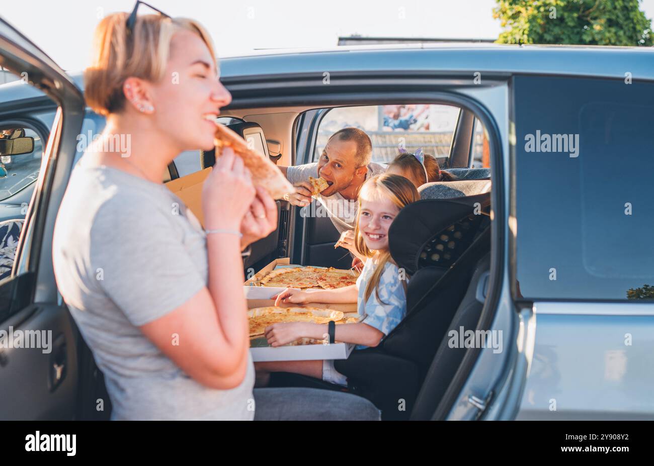 Positive smiling girl in child car seat while family car trip brake ...